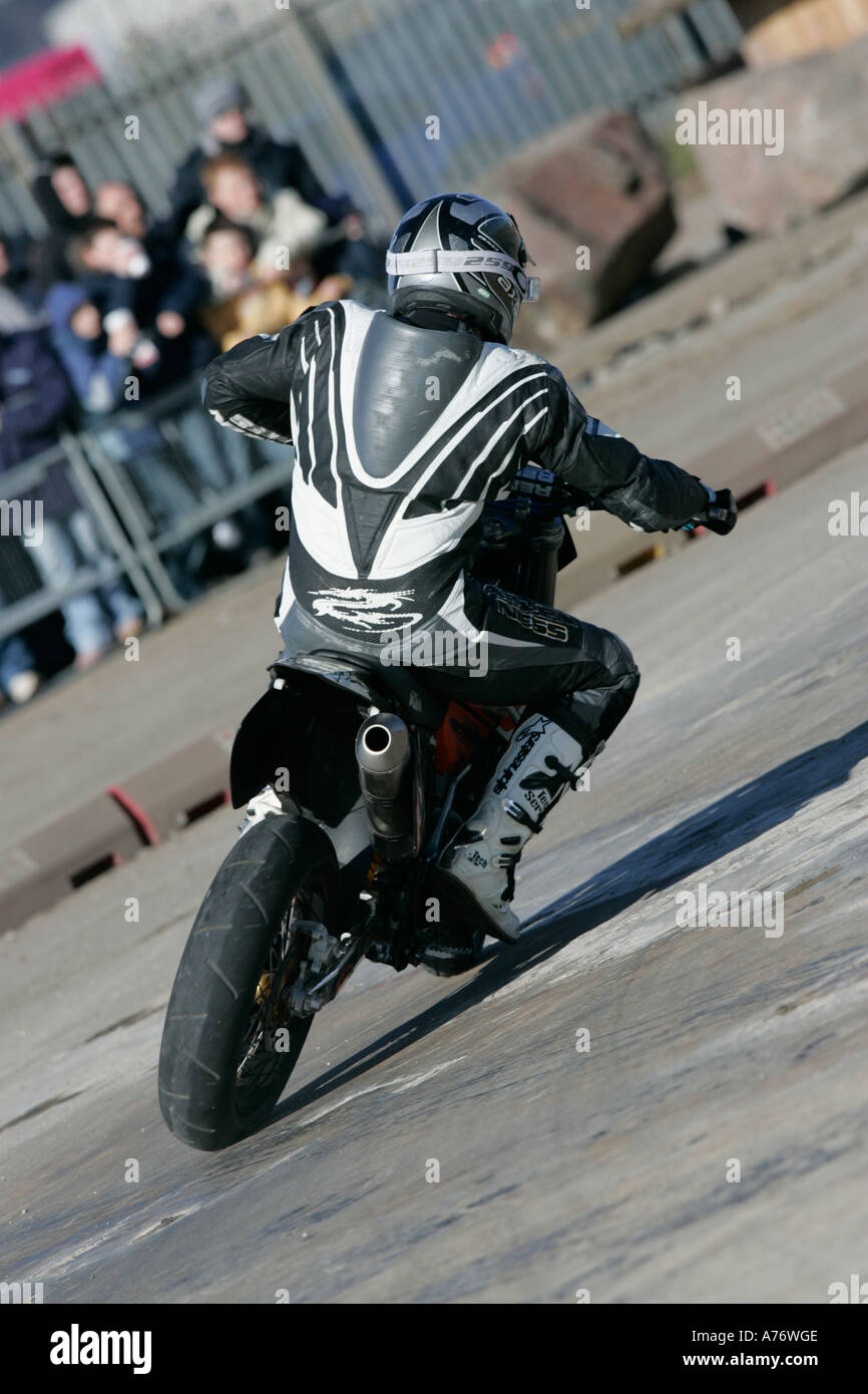 Senior supermoto competitor takes a corner rear view at demonstration ...