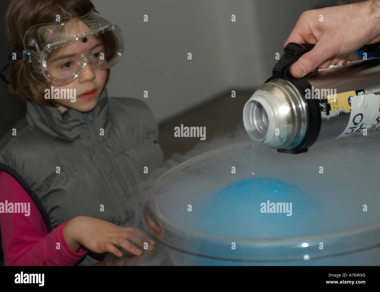Primary school pupil wearing protective goggles making a science ...