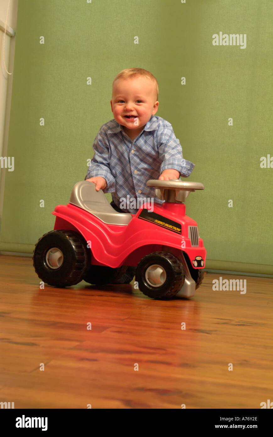 Little boy riding on toy car indoors Stock Photo - Alamy