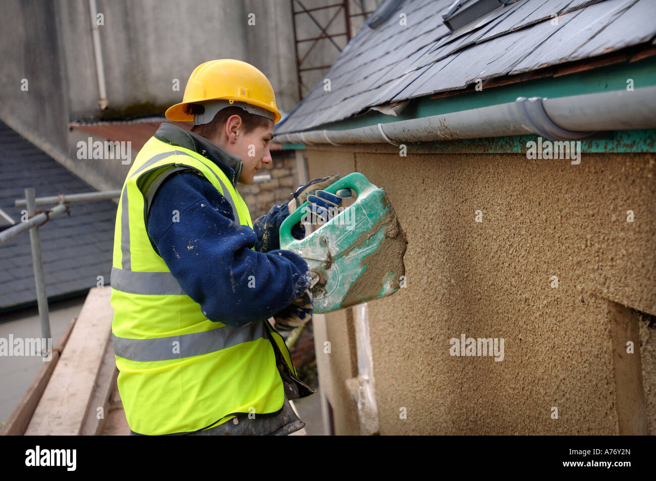 A PLASTERER RENDERING A ROUGHCAST FINISH AROUND NEW HARDWOOD CASEMENT ...