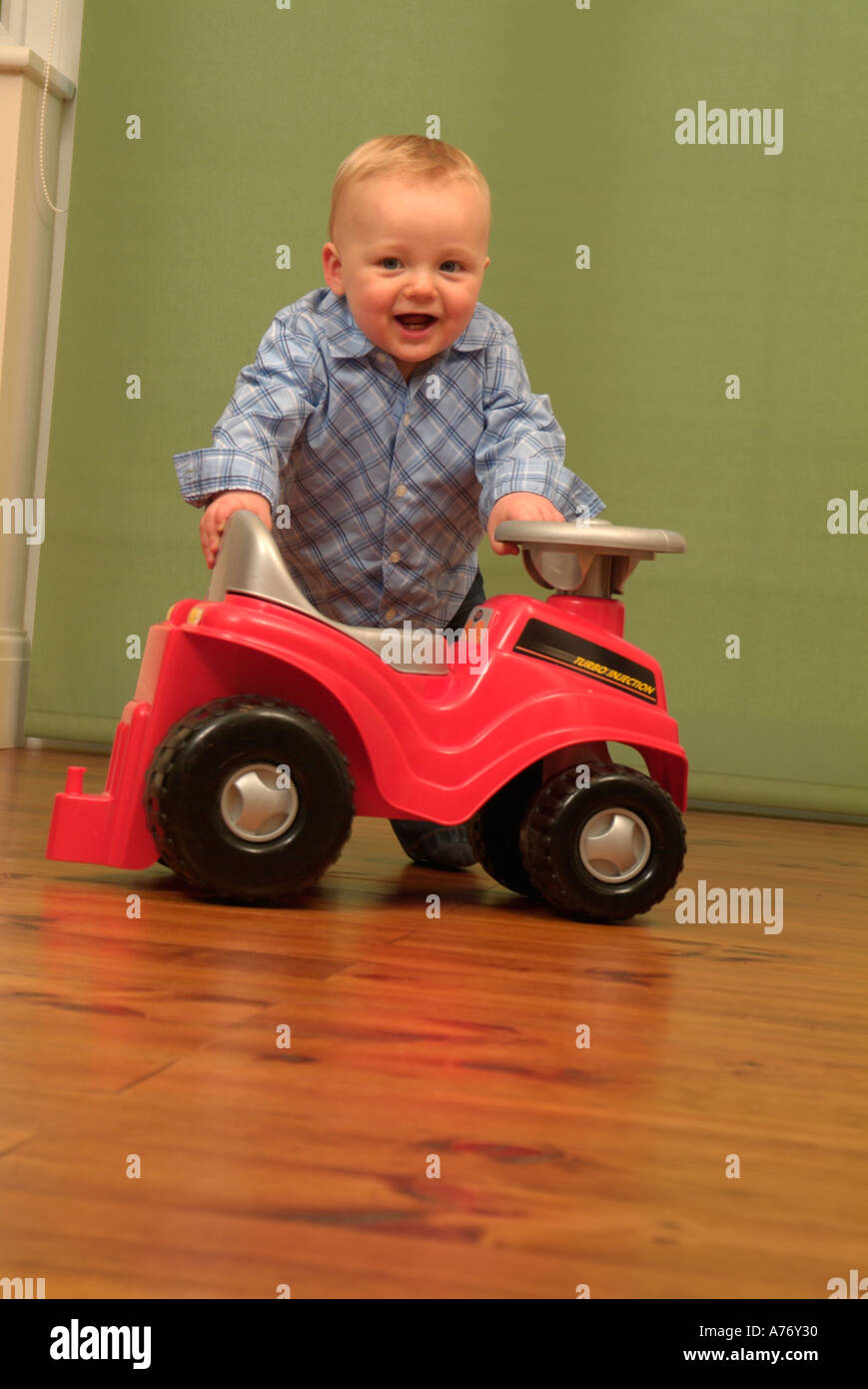 Little boy riding on toy car indoors Stock Photo - Alamy