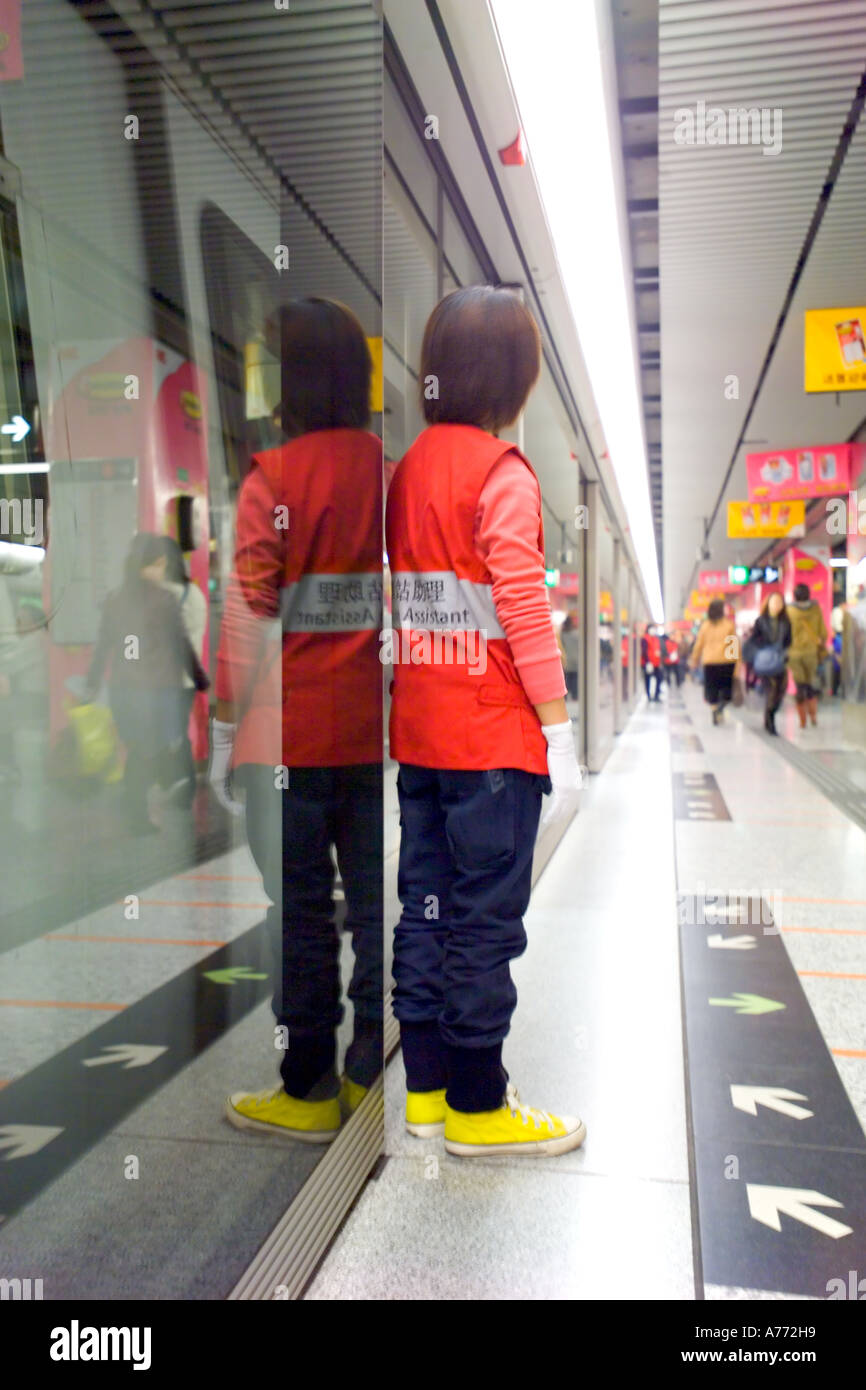 Reflection of MTR platform assistant on glass panels of platform Stock ...