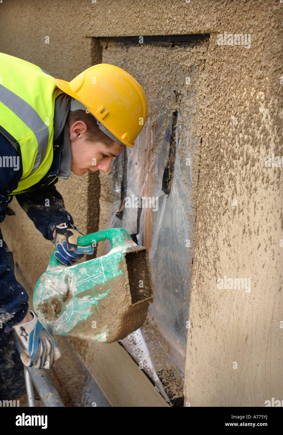 A PLASTERER RENDERING A ROUGHCAST FINISH AROUND NEW HARDWOOD CASEMENT ...