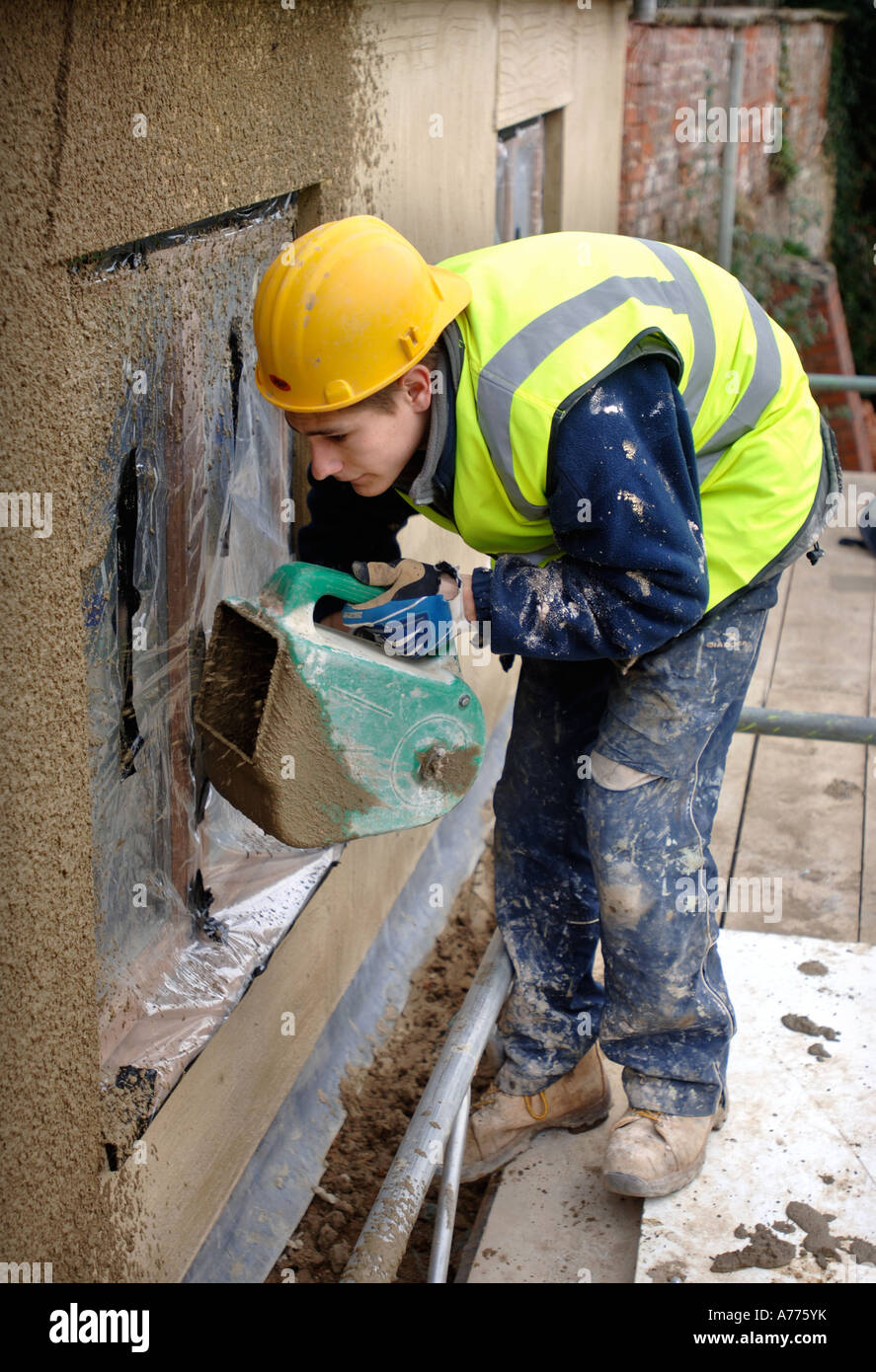 A PLASTERER RENDERING A ROUGHCAST FINISH AROUND NEW HARDWOOD CASEMENT ...
