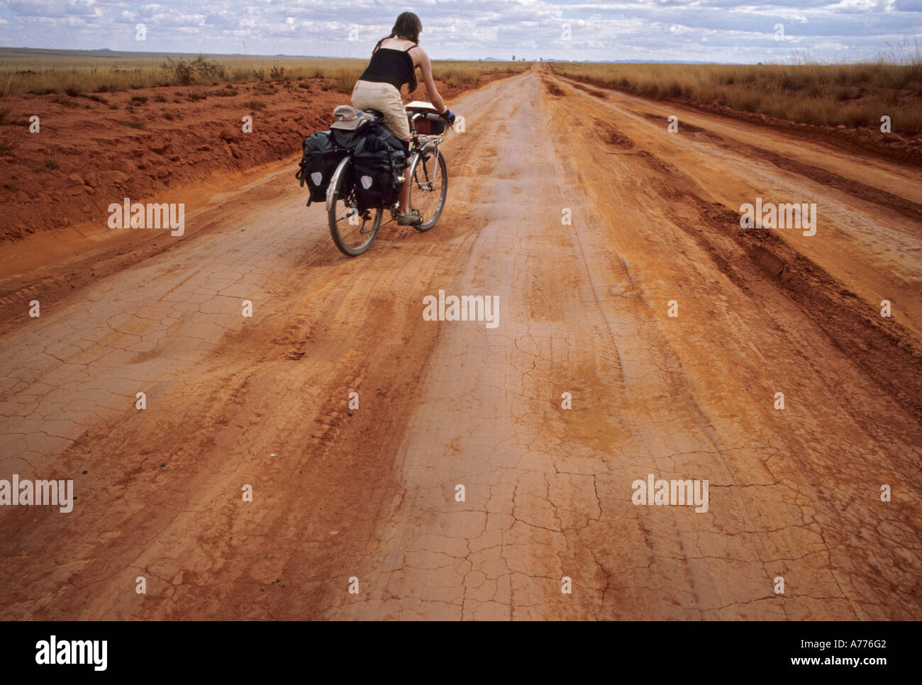 Bumpy dirt road with lone female expedition cyclist in Madagascar Stock ...