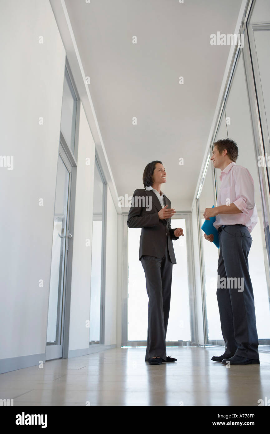 Two Businesspeople Talking in Corridor, low angle view Stock Photo - Alamy