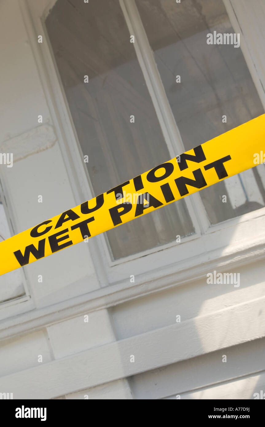 Caution wet paint warning yellow and black tape Stock Photo - Alamy