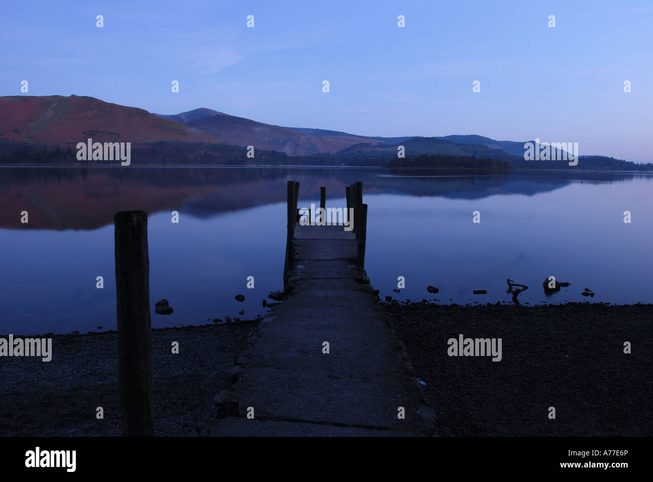 still water and Jetty at sunrise Derwent Water lake district England ...