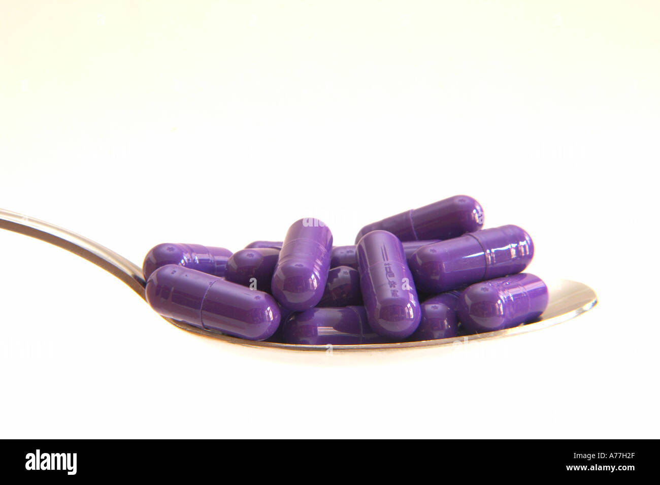 Purple capsules on a spoon Stock Photo - Alamy