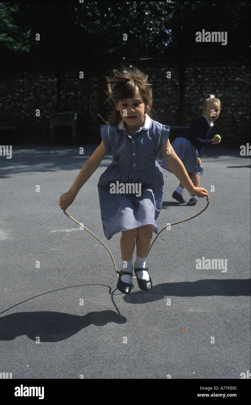 Schoolgirl skipping in school playground Stock Photo - Alamy