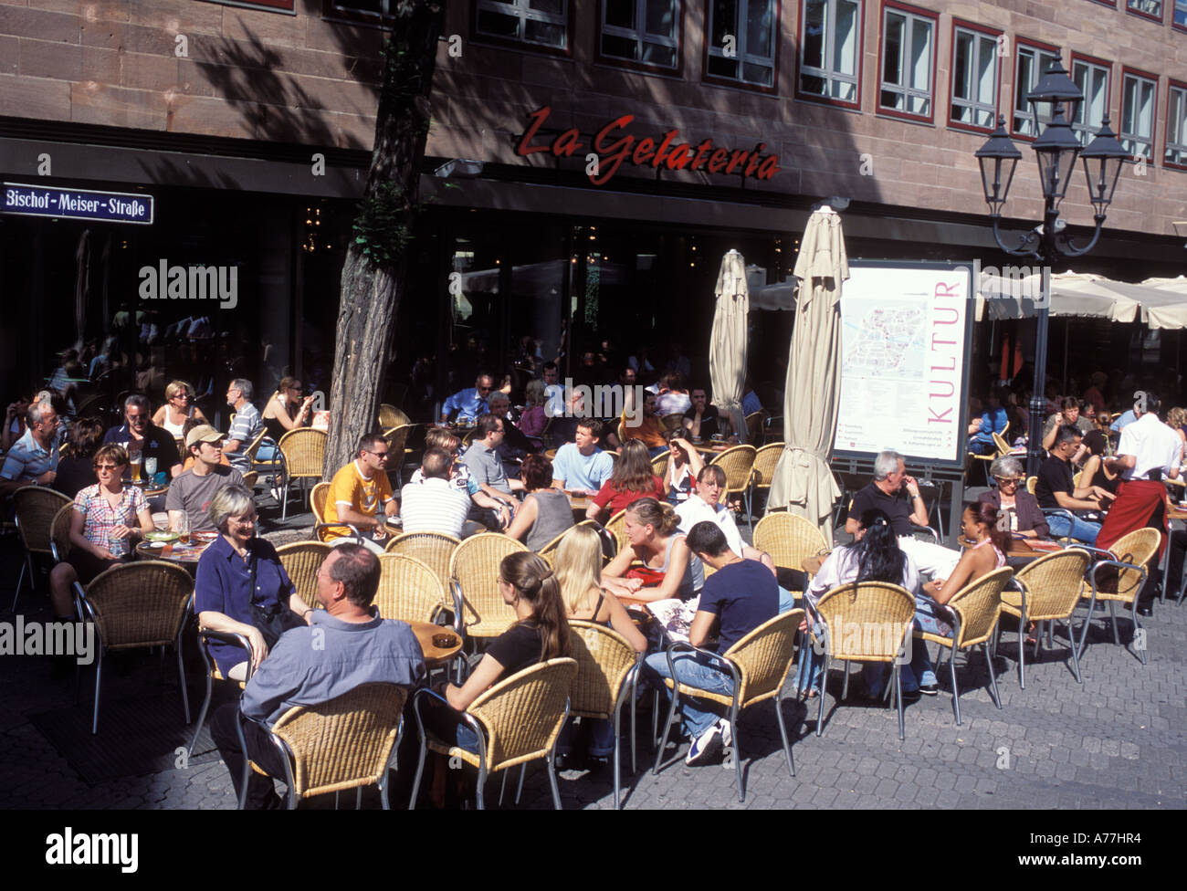 People sitting at the terrace of a Cafe and Ice Cream Parlour at ...