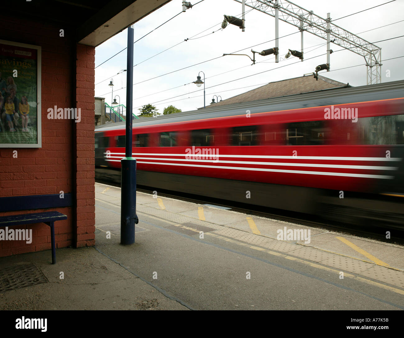 red train speeding past empty station Stock Photo - Alamy