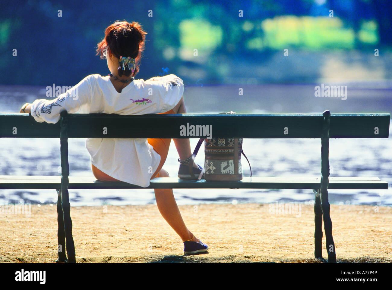 single woman sitting on a bench Stock Photo - Alamy