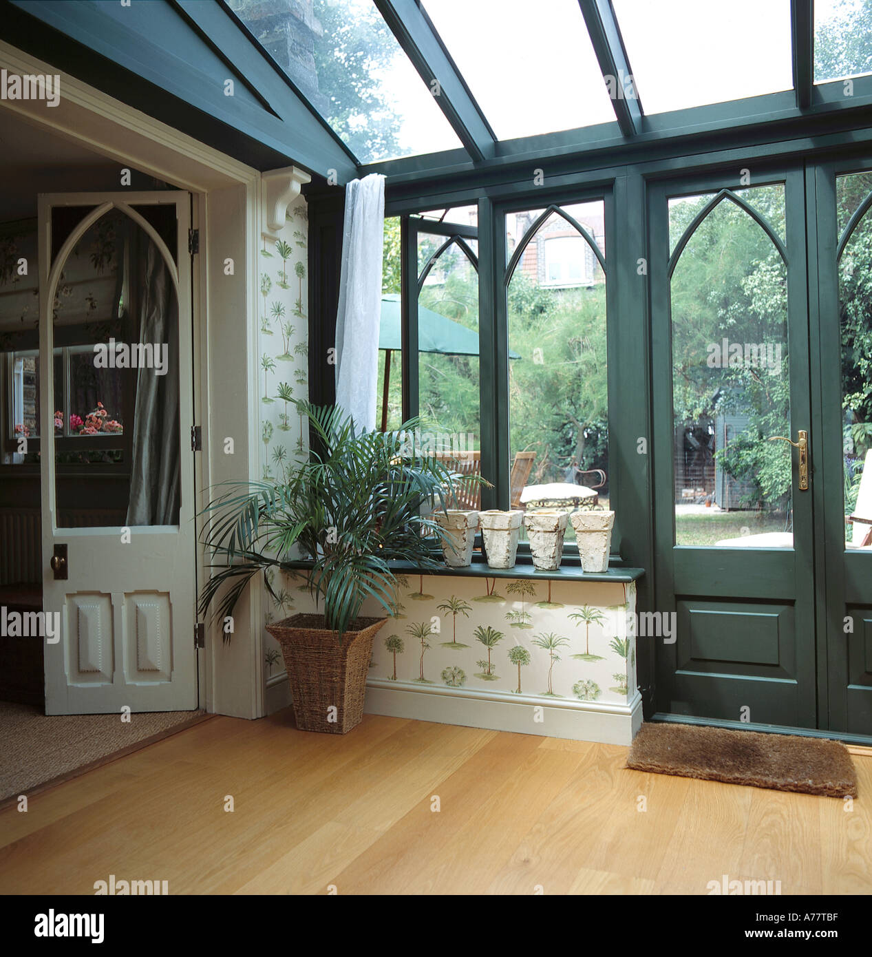 green painted wooden conservatory with wood strip floor adjacent to ...