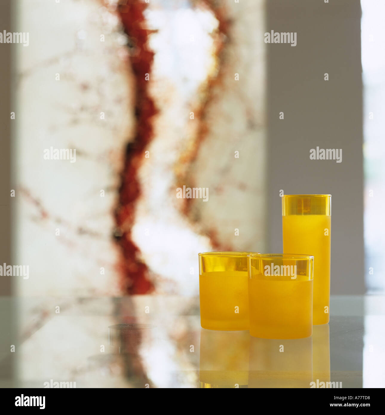 Yellow drinking glasses with stained glass panel in background Stock ...