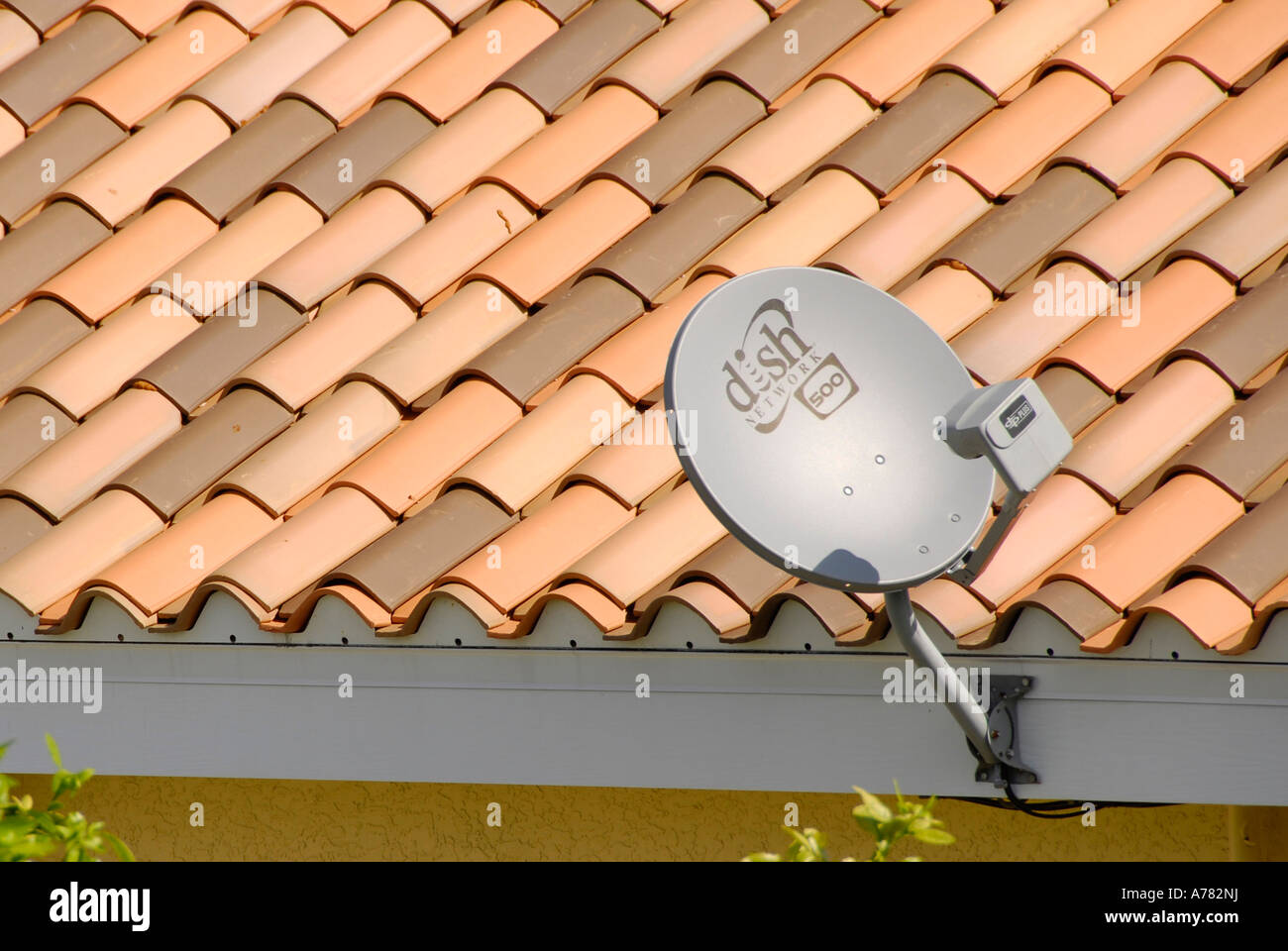 Satellite television dish mounted on the side of a home with a tiled ...