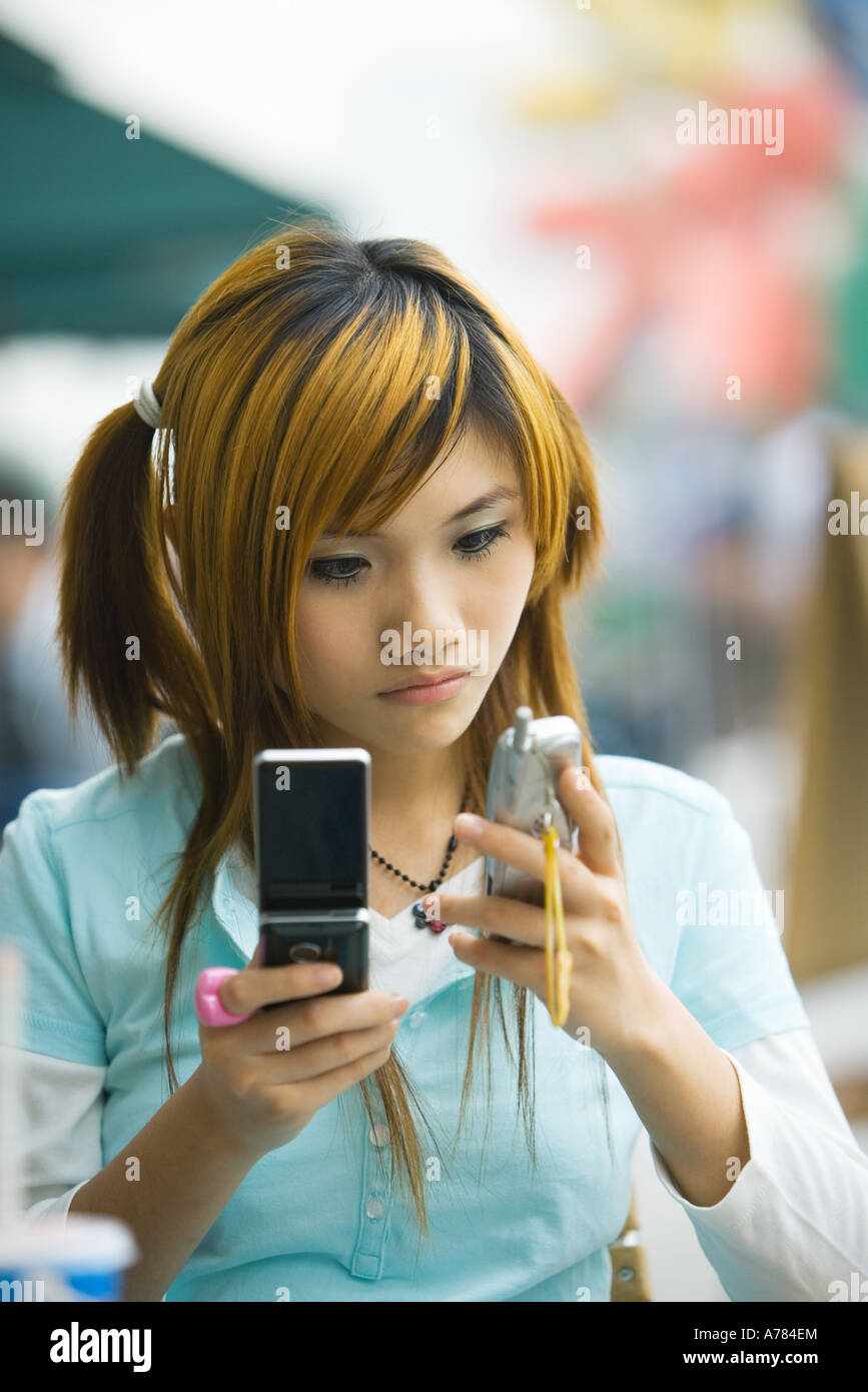 Teenage girl using two cell phones Stock Photo - Alamy