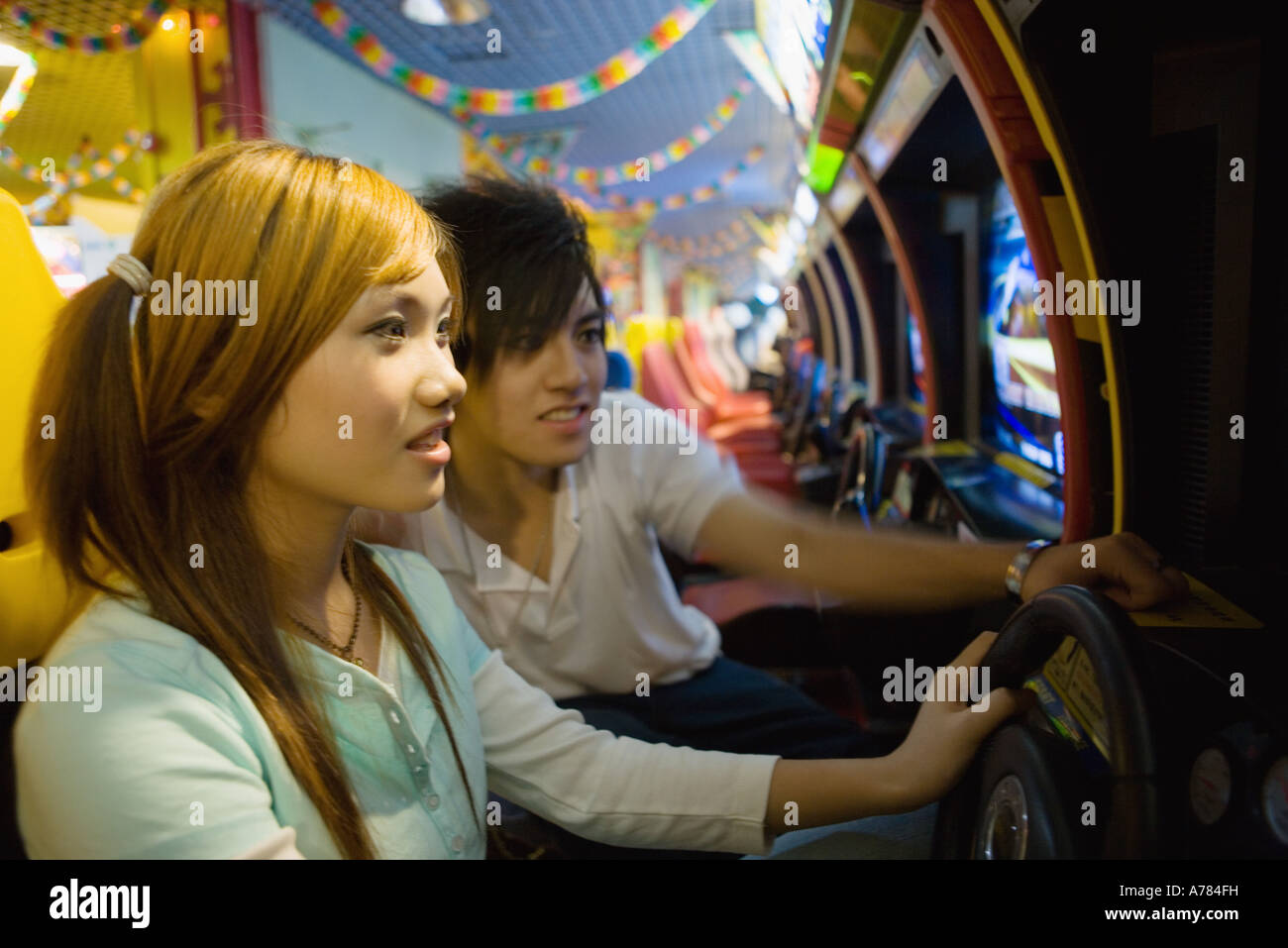 Teenage couple playing games in video arcade Stock Photo - Alamy