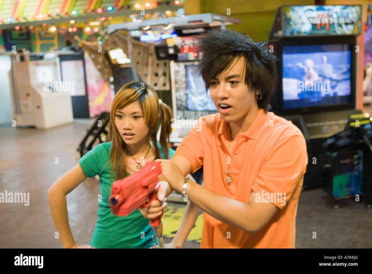 Teenage couple playing game in video arcade Stock Photo - Alamy