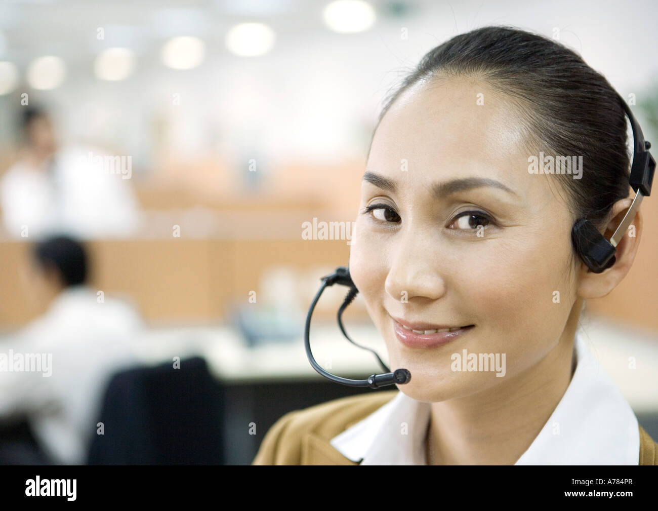 Woman wearing headset, smiling at camera Stock Photo - Alamy