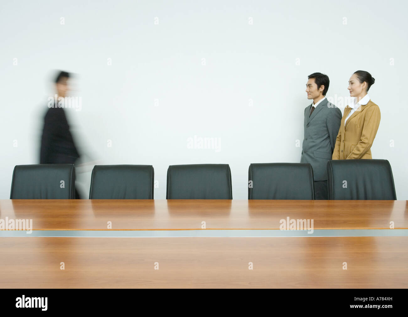 Two business partners greeting associate in conference room Stock Photo ...