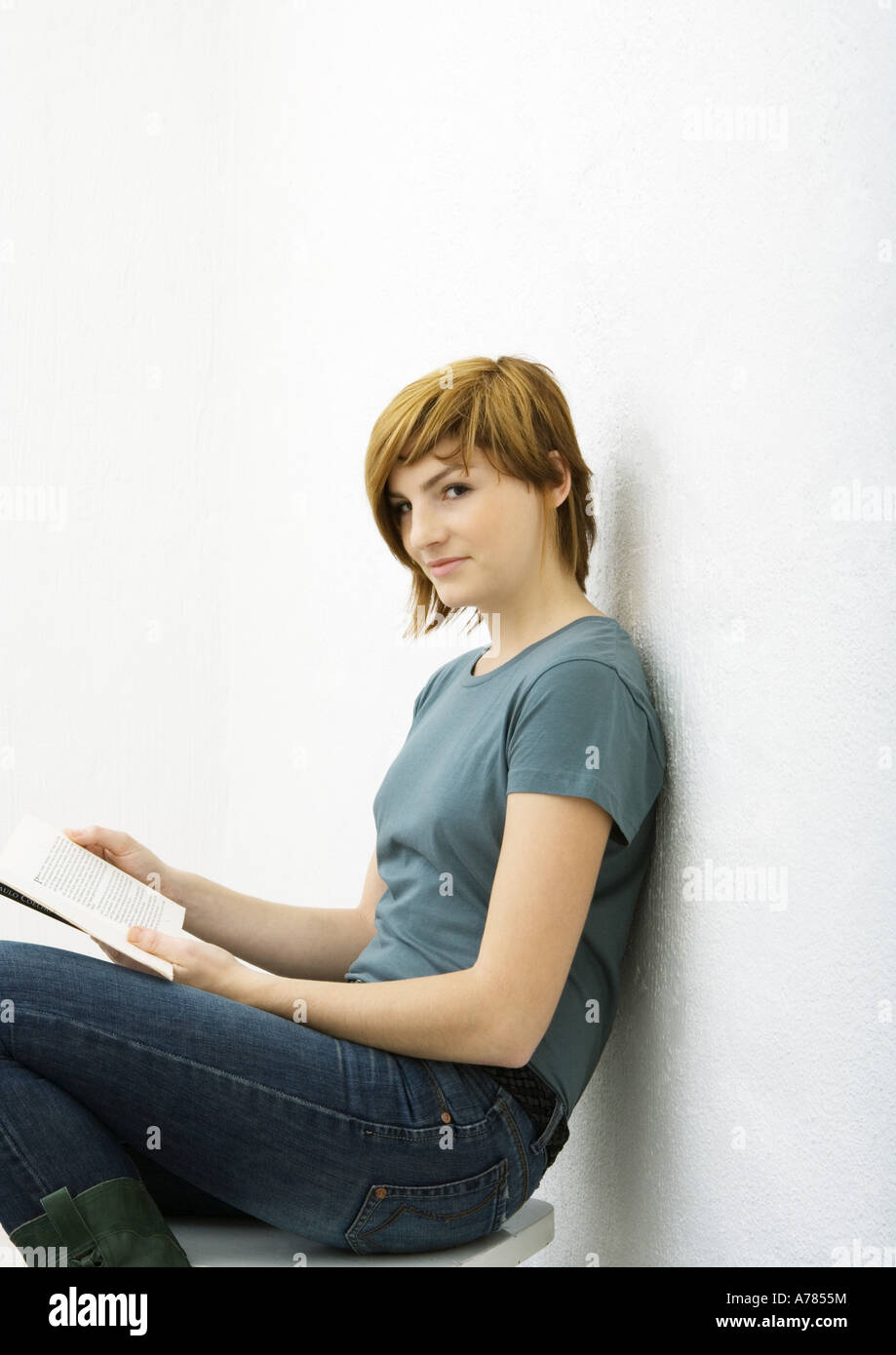 Young woman sitting with book, portrait Stock Photo - Alamy