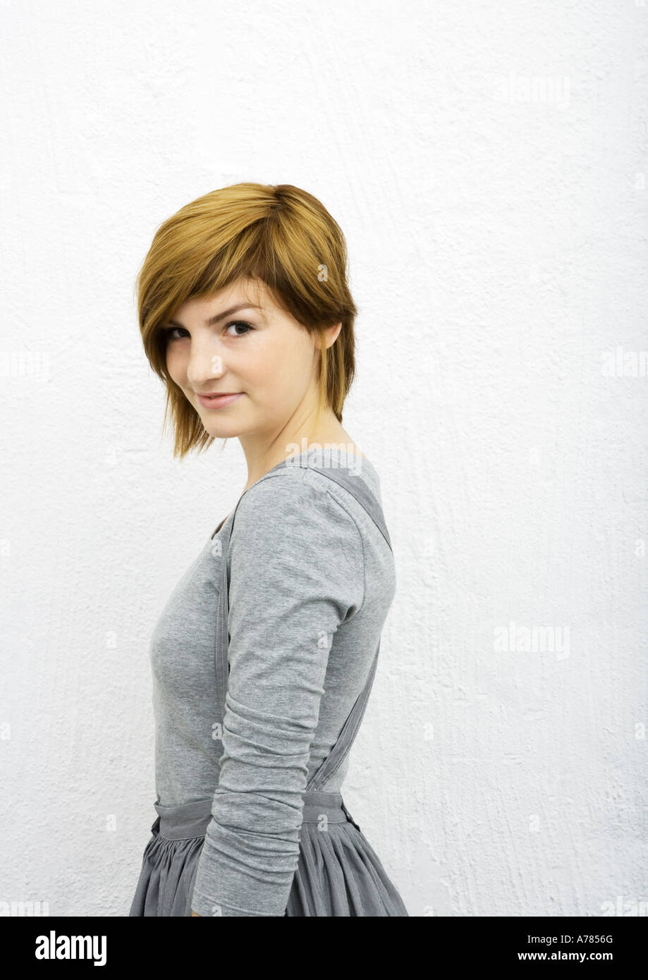 Young woman looking over shoulder at camera, portrait Stock Photo - Alamy