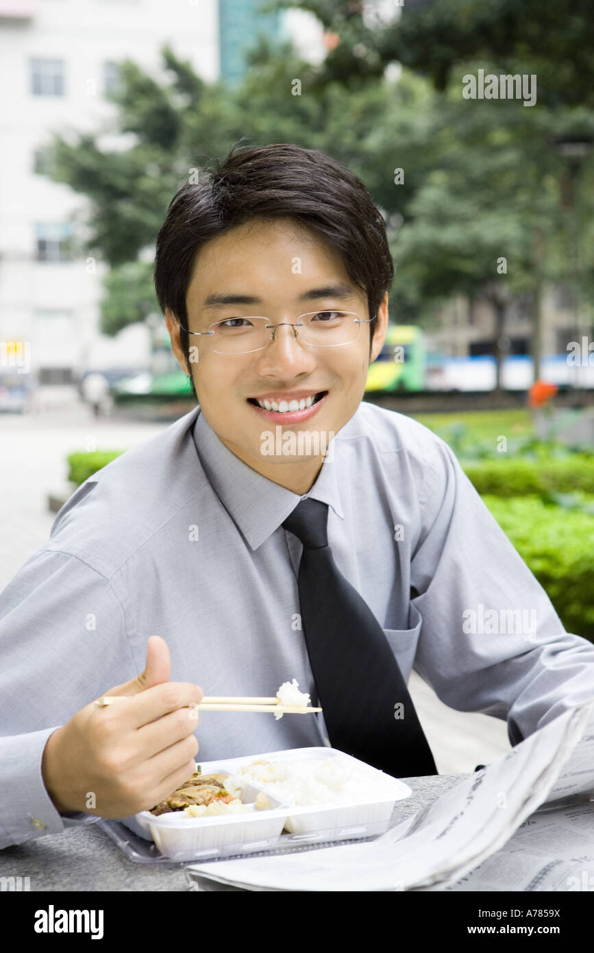 Young businessman eating takeout food outdoors Stock Photo - Alamy