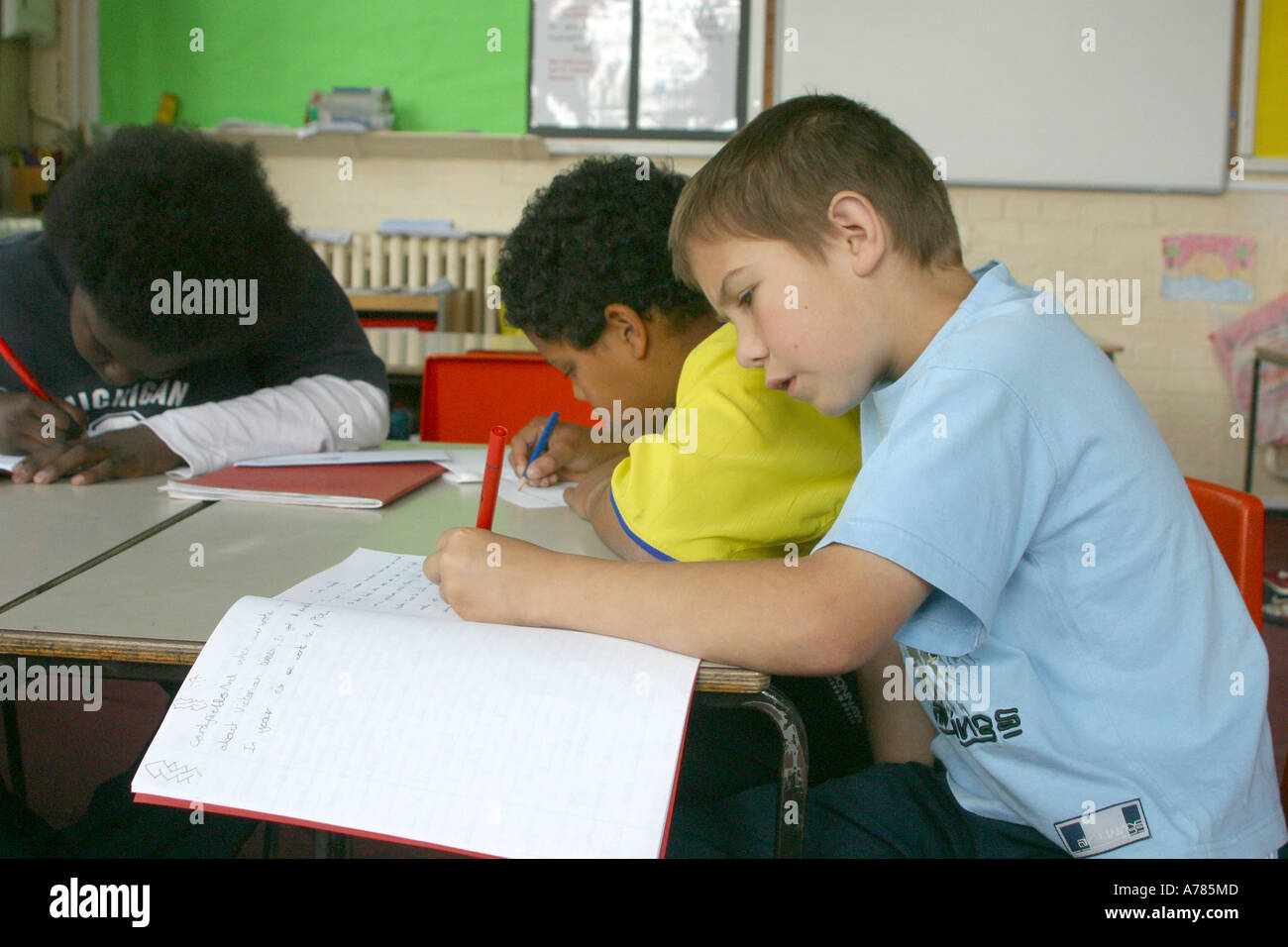 Primary school boys at their desks working on a lesson Stock Photo - Alamy