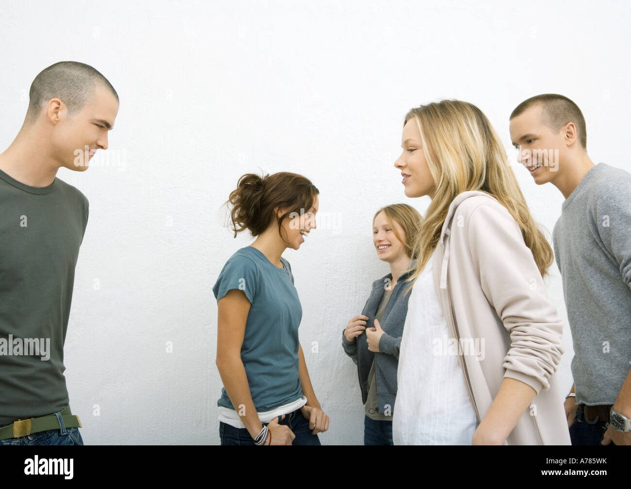 Group of casually dressed young adults, moving toward each other, side ...