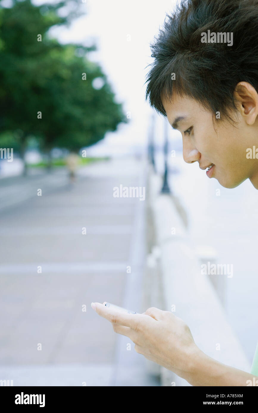 Young man using cell phone, cropped view of head and hand Stock Photo ...