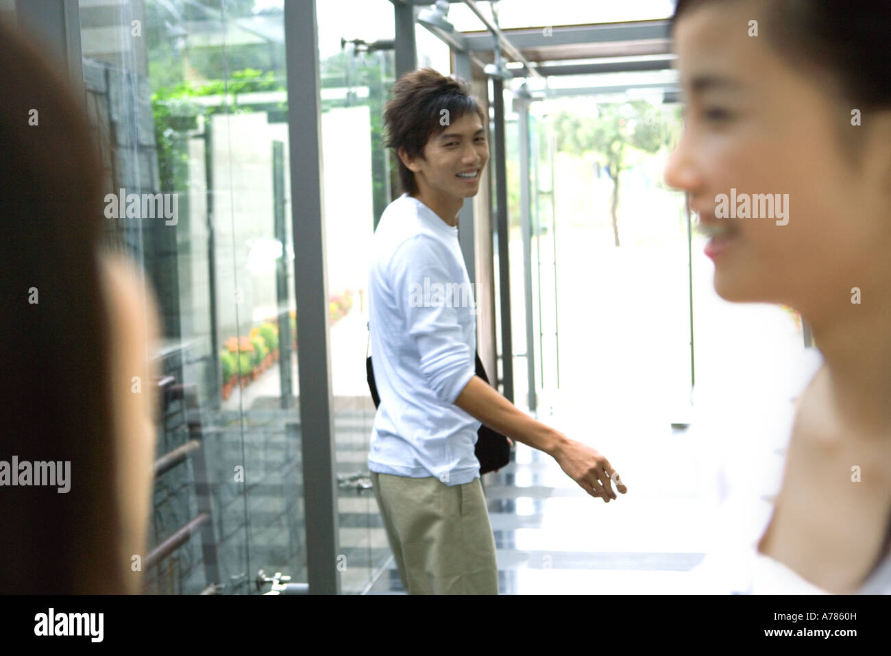 Young man walking away from friends Stock Photo - Alamy