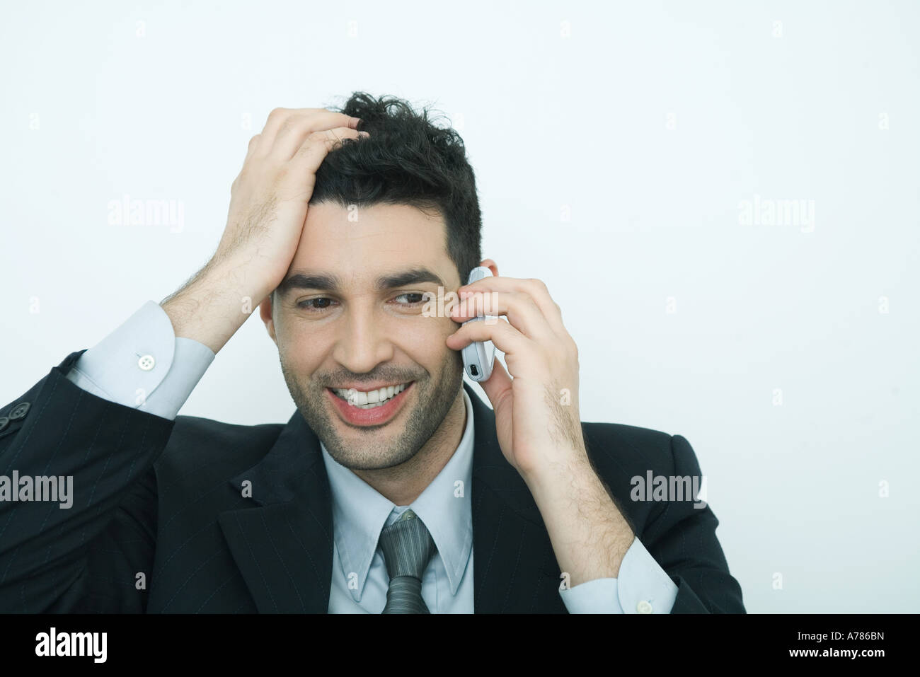 Businessman using cell phone, holding head Stock Photo - Alamy