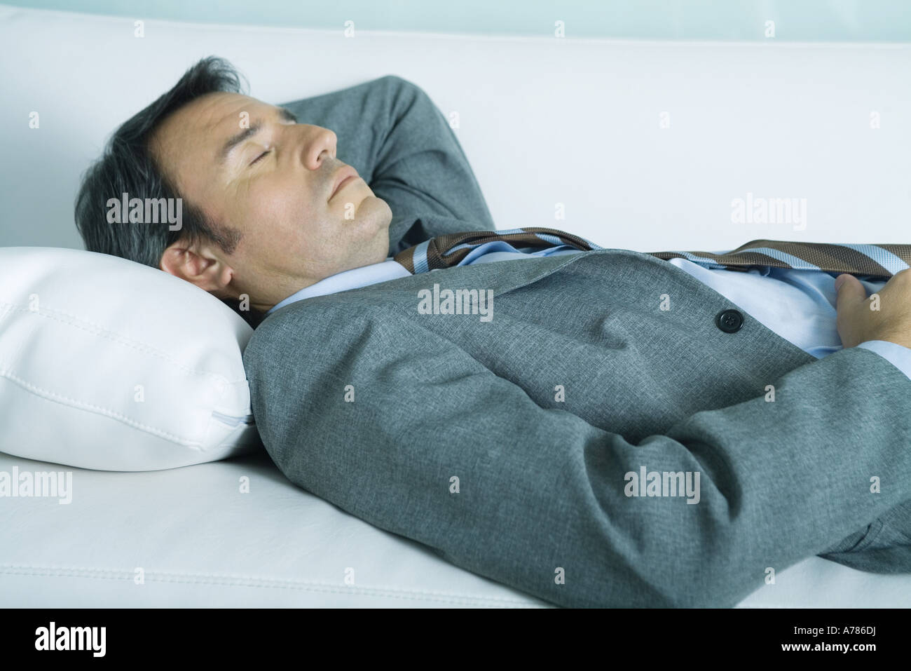 Businessman sleeping on sofa Stock Photo - Alamy