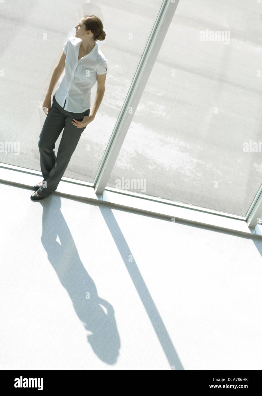 Woman standing by window, full length, high angle view Stock Photo - Alamy