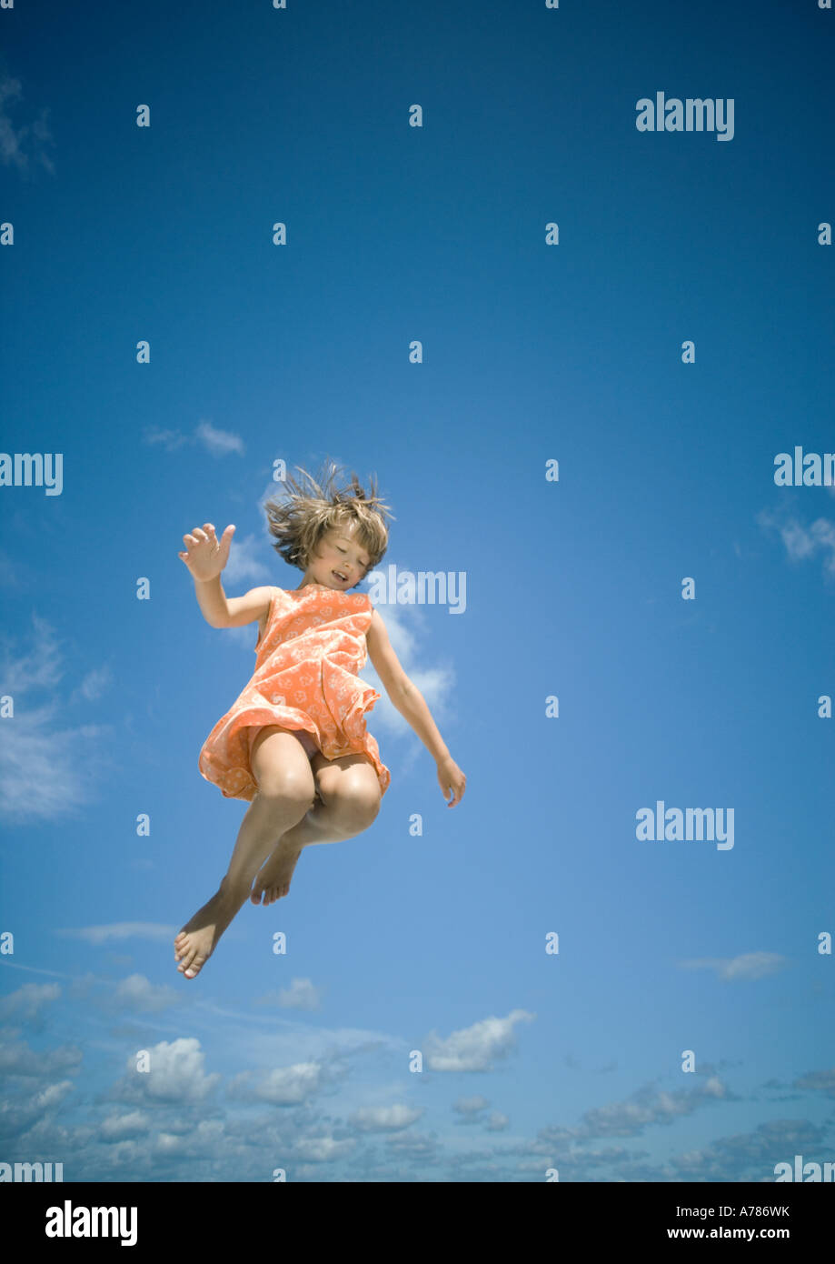 Girl jumping, sky in background, low angle view Stock Photo - Alamy