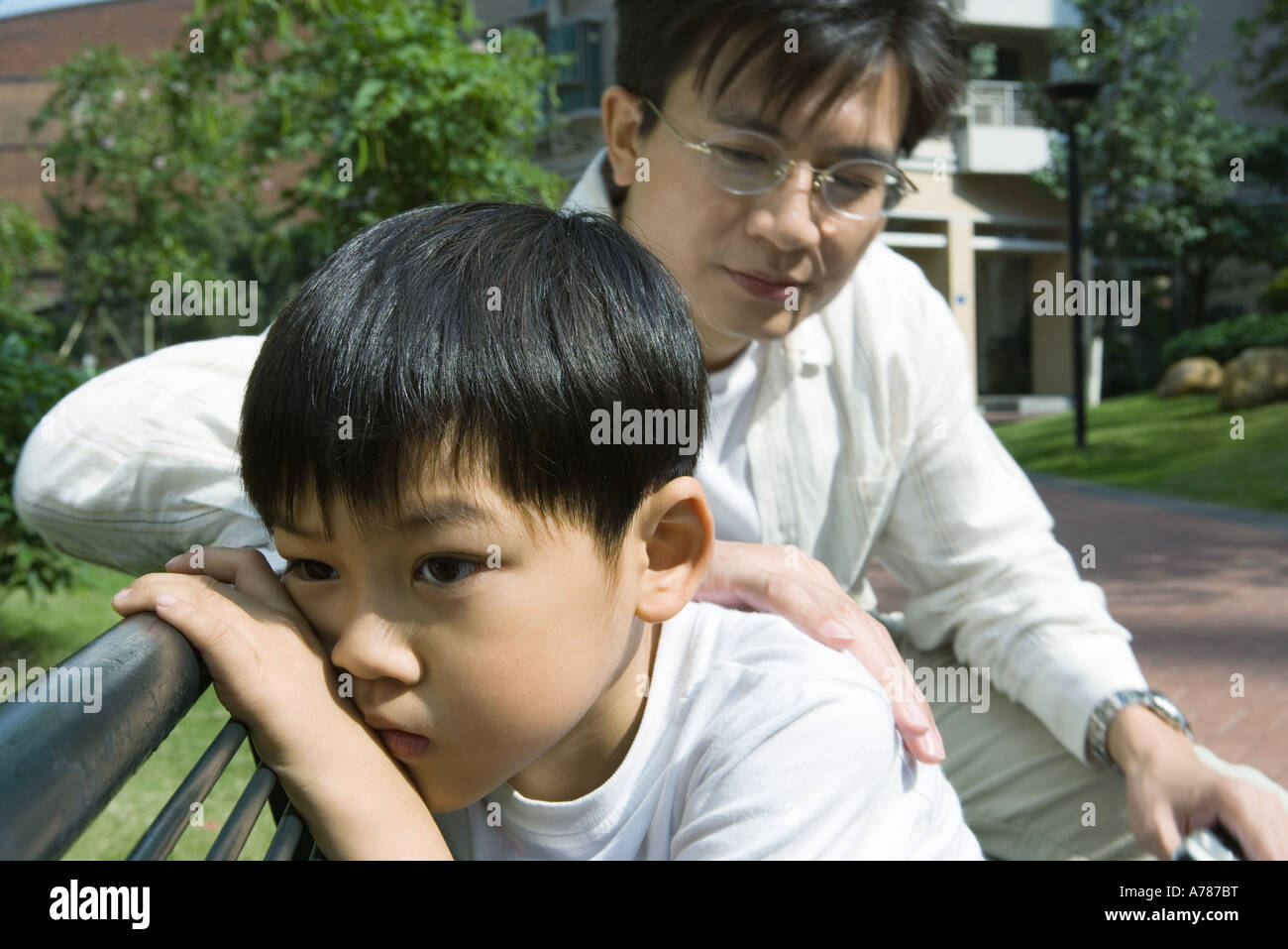 Father and son on bench, boy pouting Stock Photo - Alamy