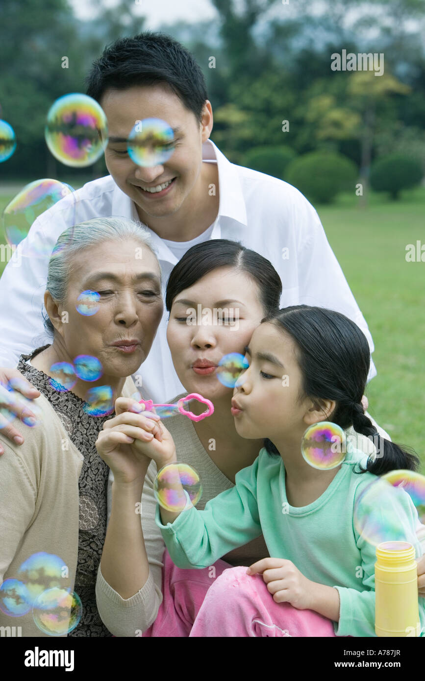 Three generation family blowing bubbles Stock Photo - Alamy