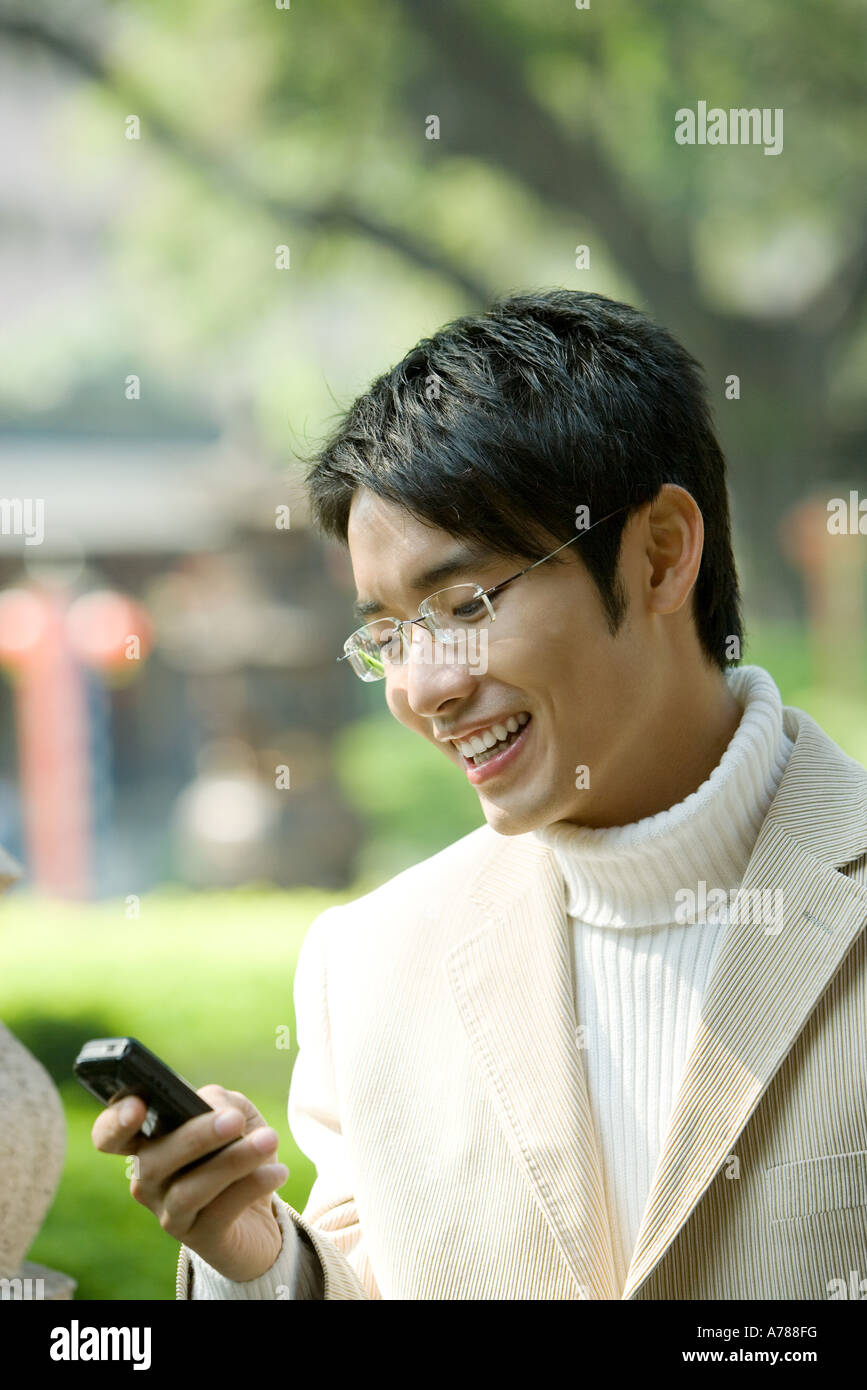 Man looking at cell phone, smiling Stock Photo - Alamy