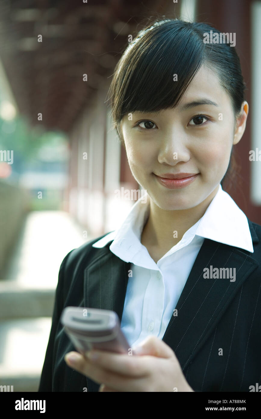 Woman holding cell phone, smiling at camera, portrait Stock Photo - Alamy