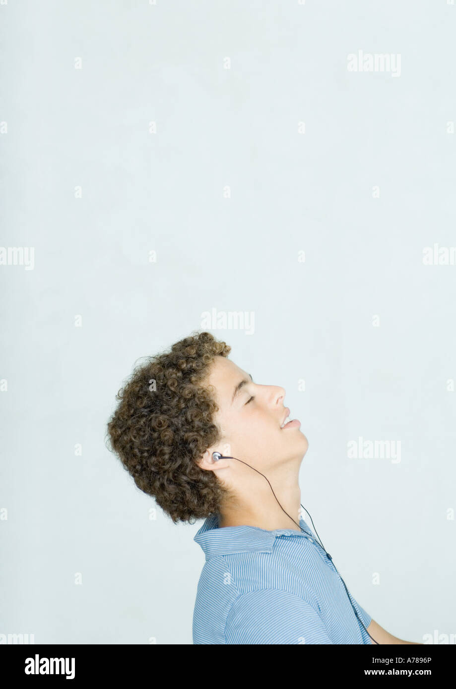 Teenage boy listening to earphones Stock Photo - Alamy