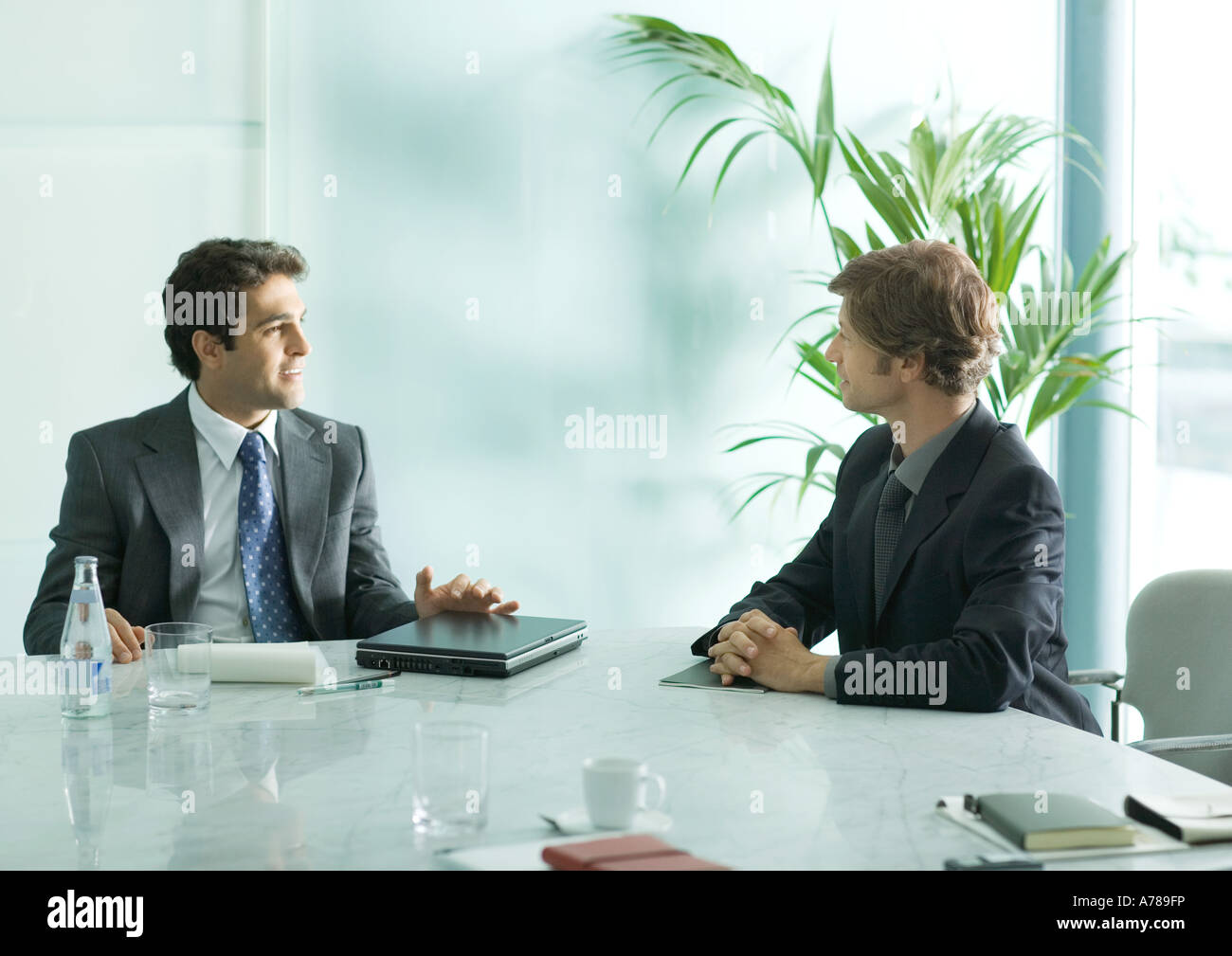 Two businessmen sitting at table, having meeting Stock Photo - Alamy