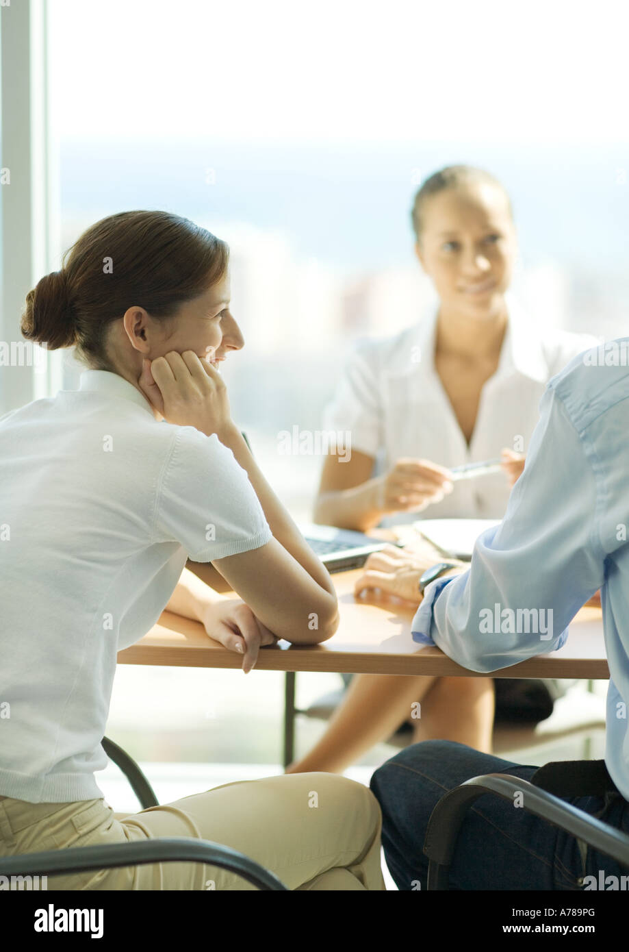Young couple sitting across table from young female professional Stock ...