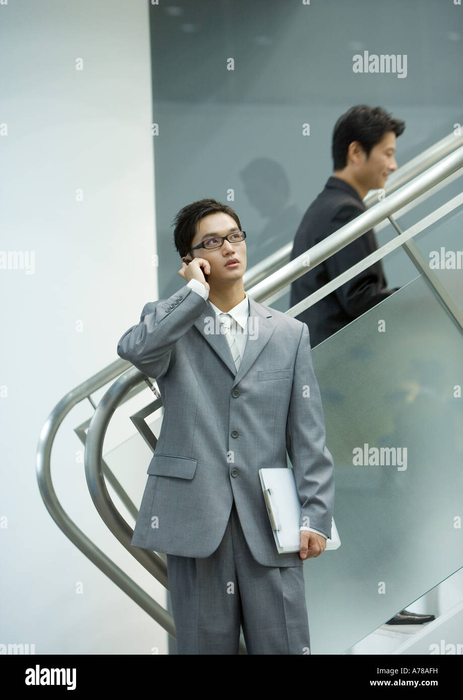 Businessman using cell phone near staircase Stock Photo - Alamy