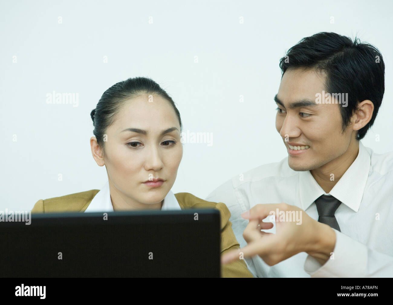 Two business associates using computer, man pointing toward screen ...