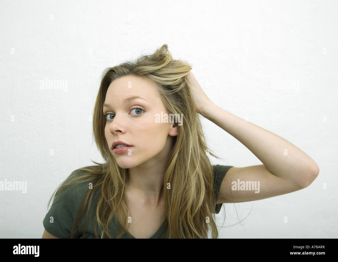 Teenage girl pushing hair back and looking at camera, portrait Stock ...