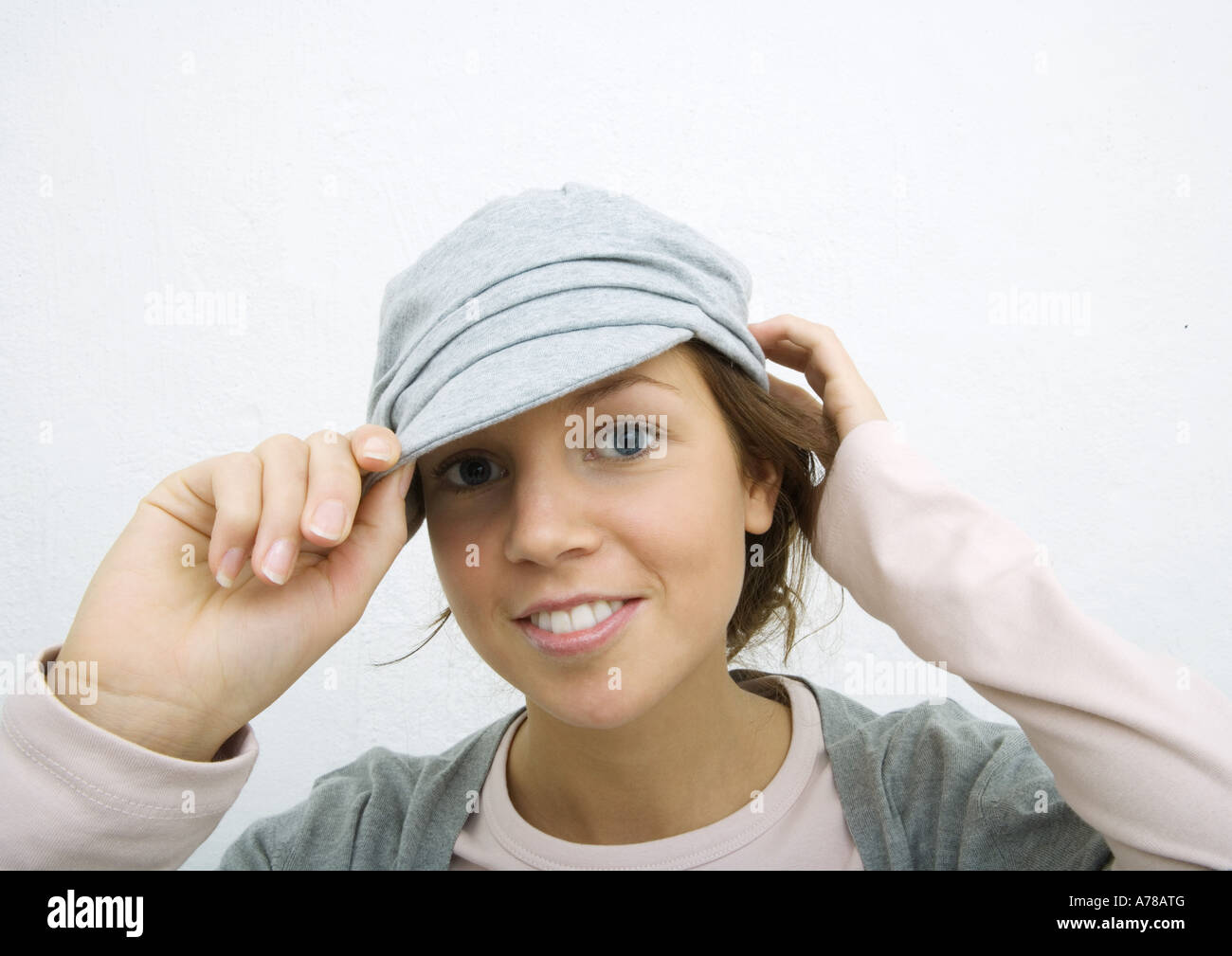 Young woman adjusting cap, portrait Stock Photo - Alamy
