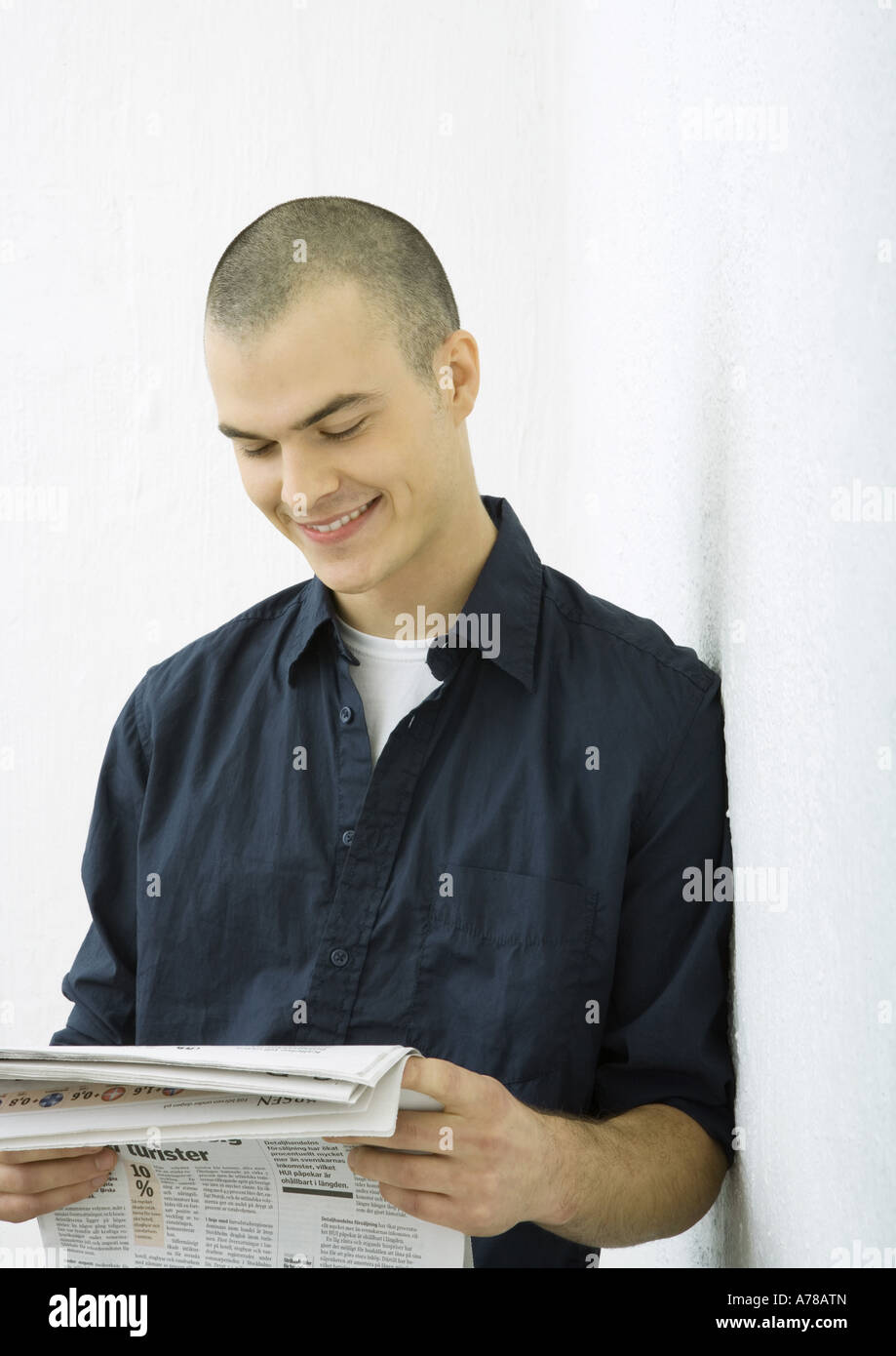 Young man reading newspaper, portrait Stock Photo - Alamy