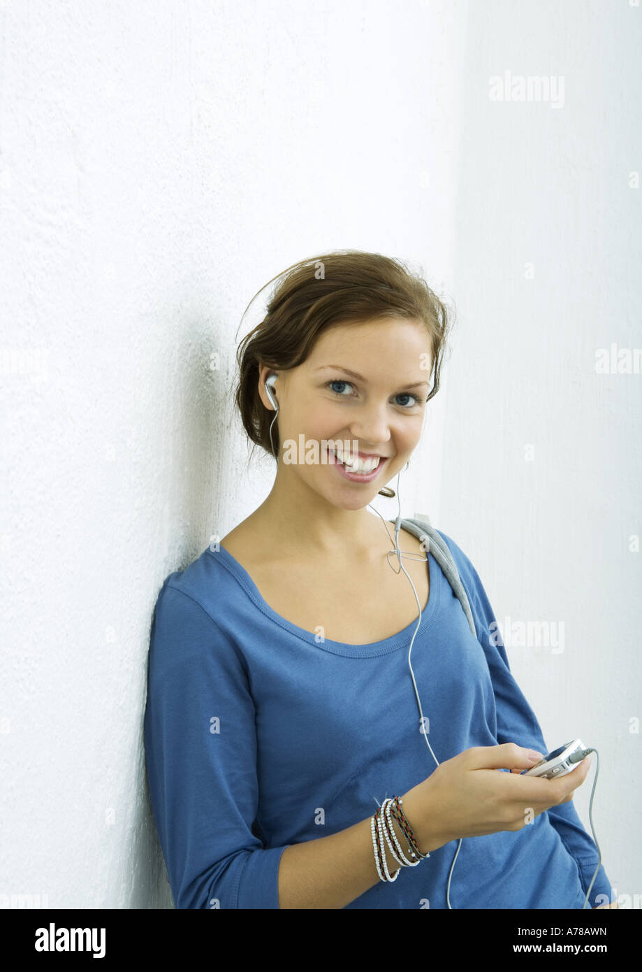 Young woman listening to MP3 player, portrait Stock Photo - Alamy