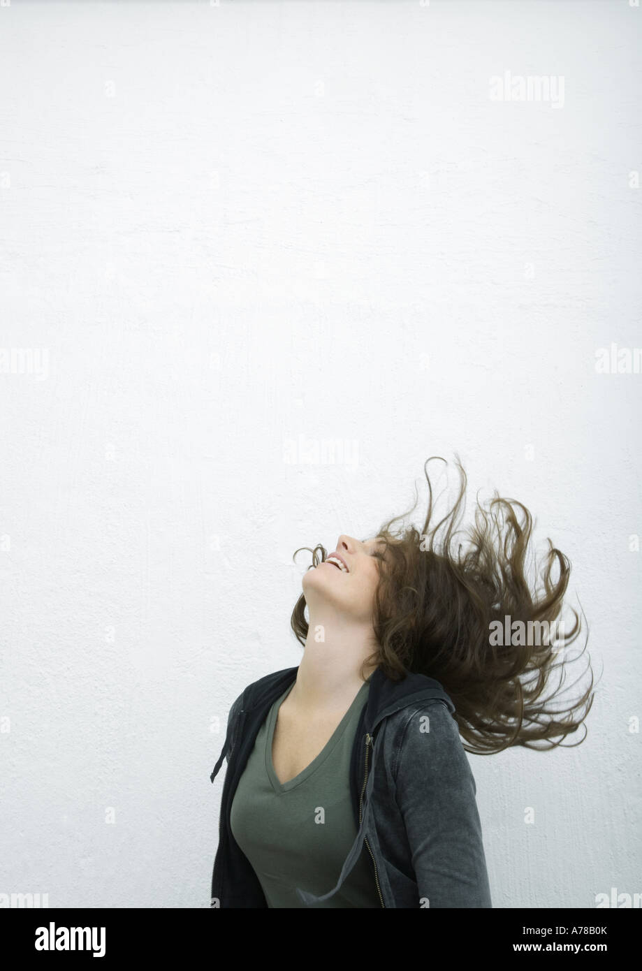 Young woman flipping hair back, white background Stock Photo - Alamy